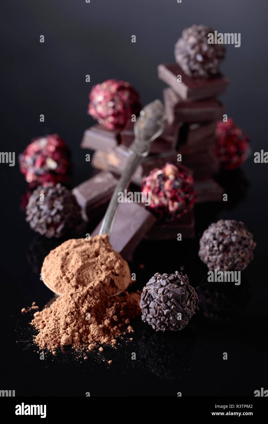 Chocolate candies, broken chocolate pieces and spoon with cocoa powder ...