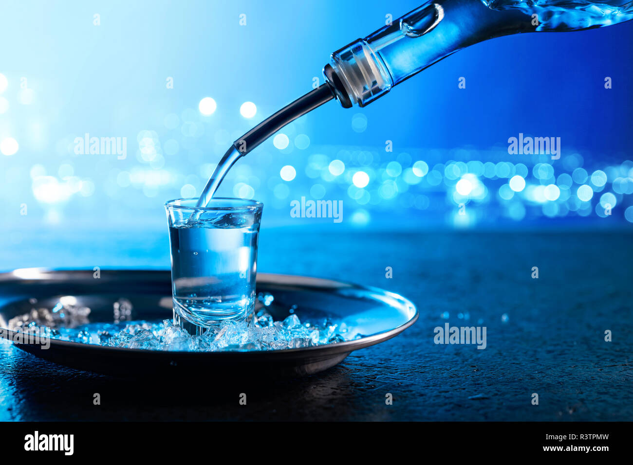 Vodka poured into a glass lit with blue backlight. Copy space.Chilled ...