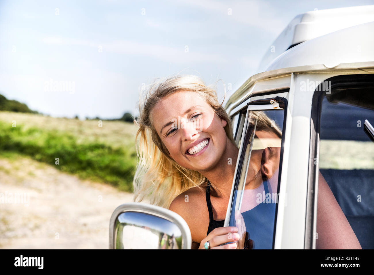 Happy woman looking out of window of a van Stock Photo - Alamy