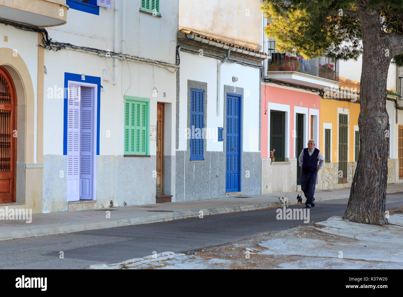 Spain, Balearic Islands, Mallorca. Porto Colom. Man walking his two ...