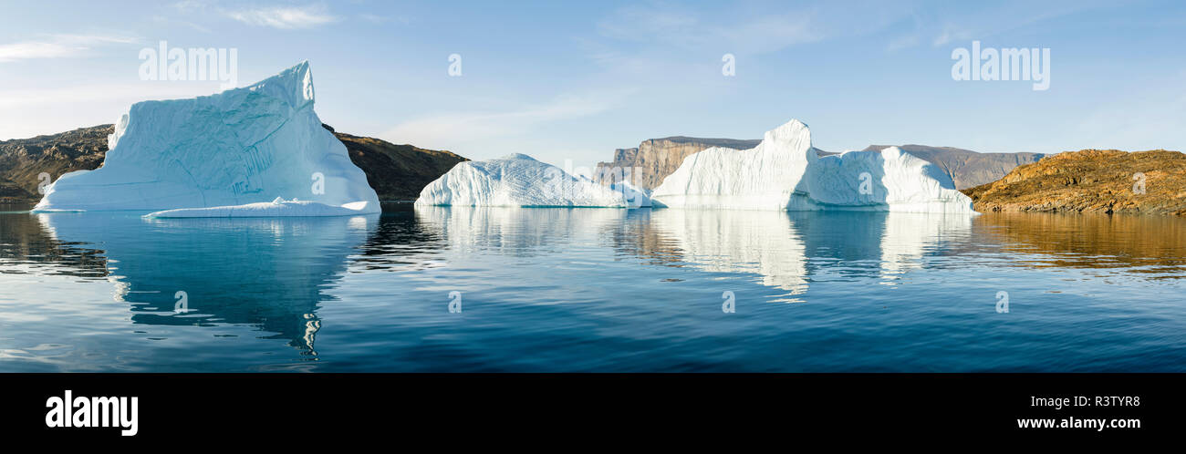 Landscape with steep yellow cliffs and icebergs in the Uummannaq fjord ...