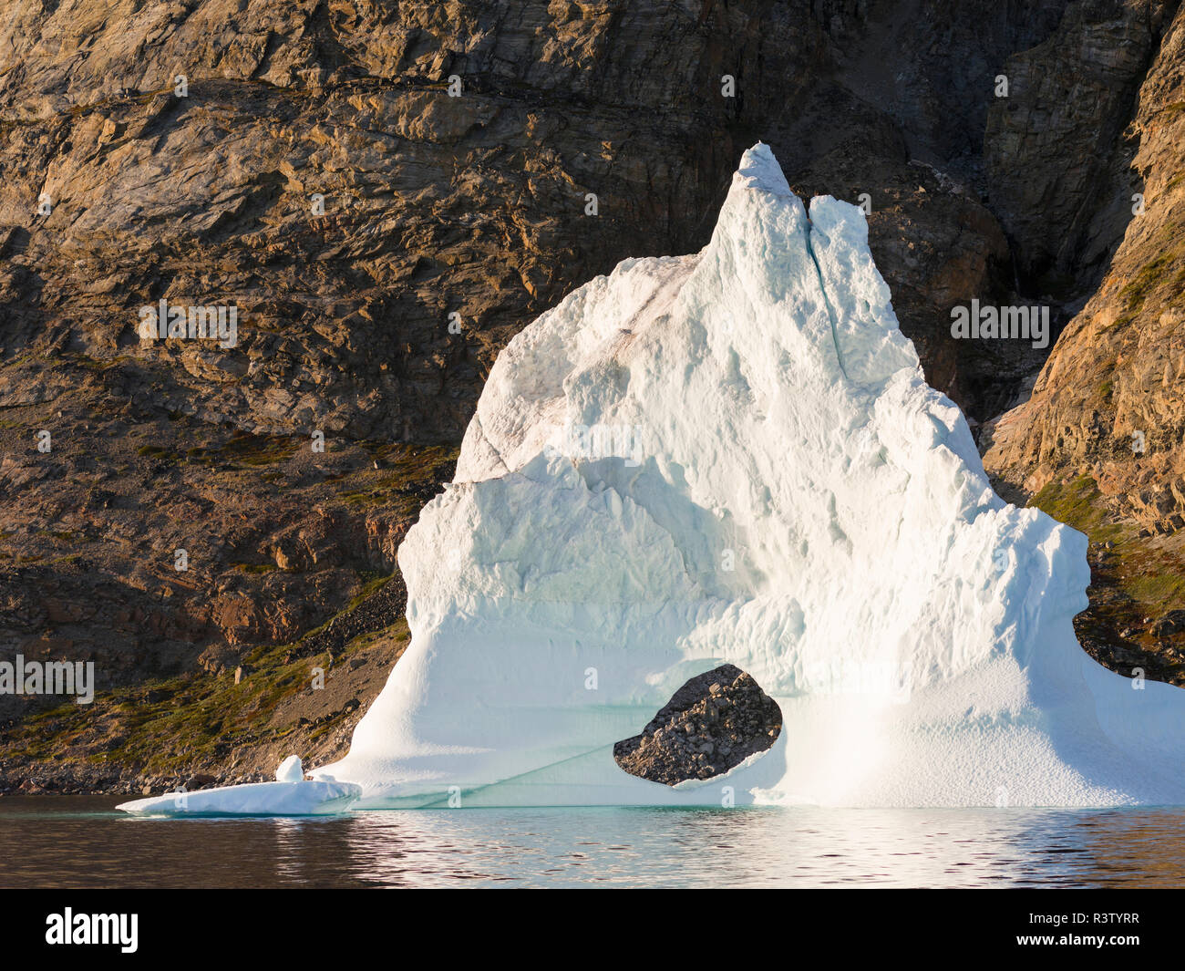 Landscape with steep yellow cliffs and icebergs in the Uummannaq fjord ...