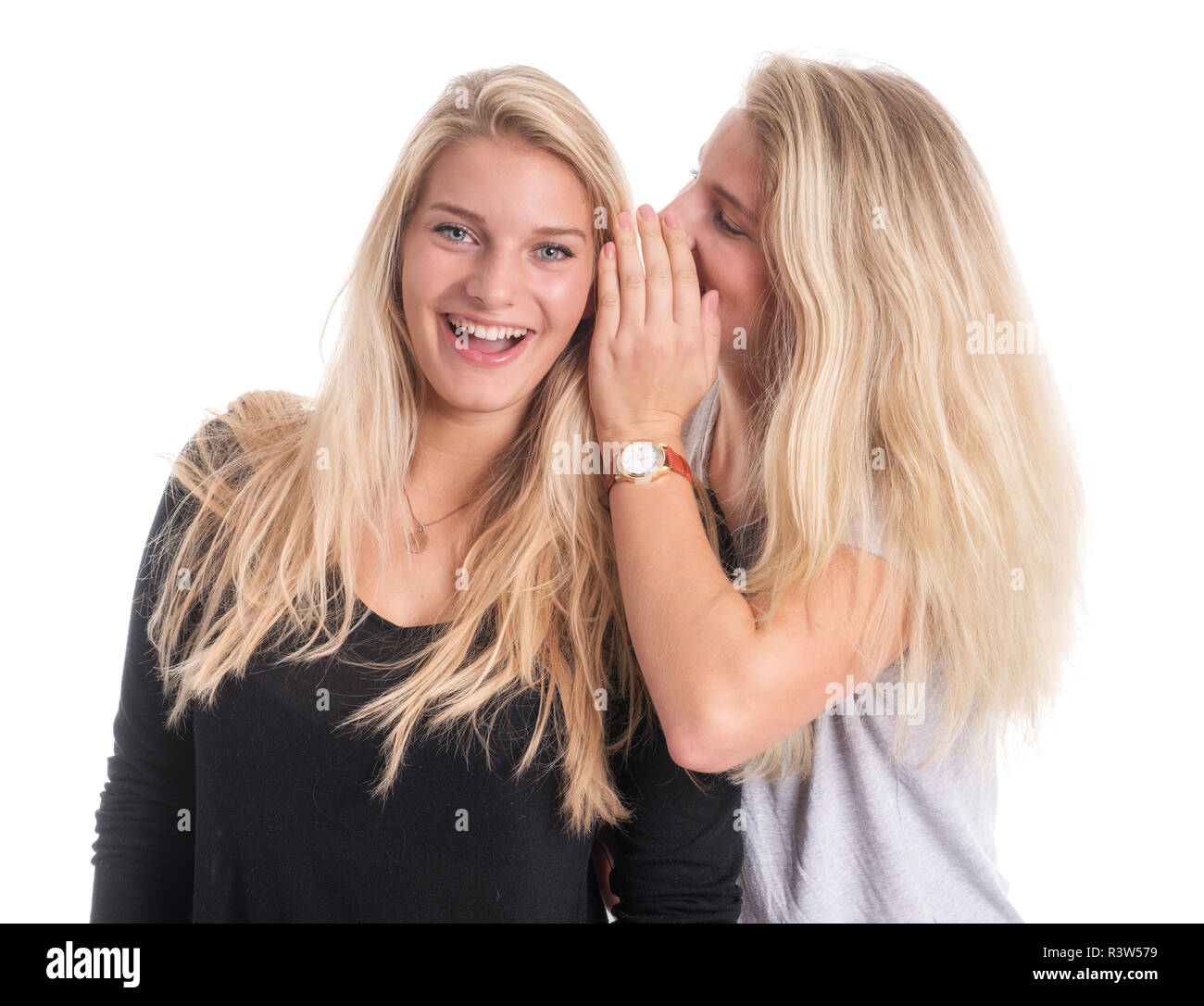 two blond young girls whisper together Stock Photo - Alamy