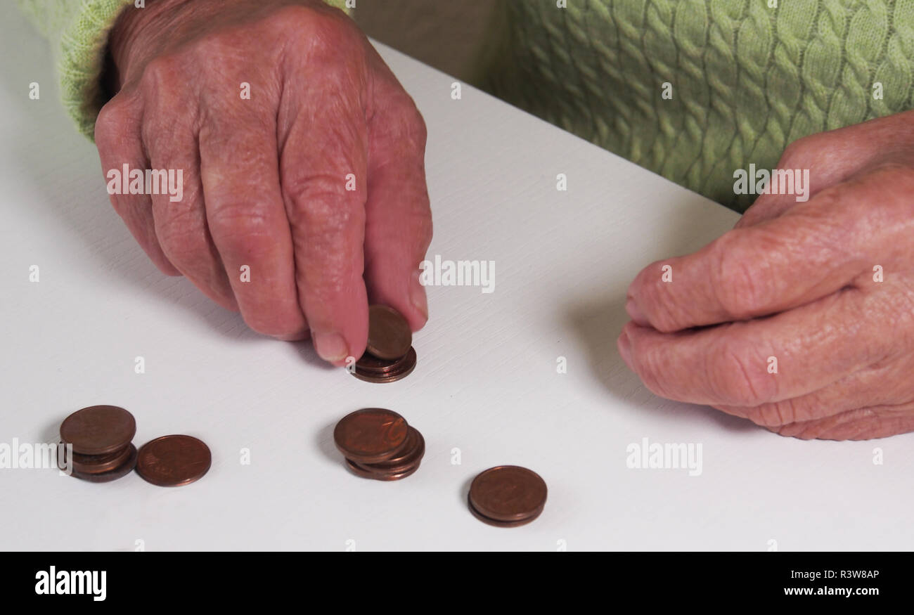 Woman's hands are holding a few euro coins. Pension, poverty, social ...