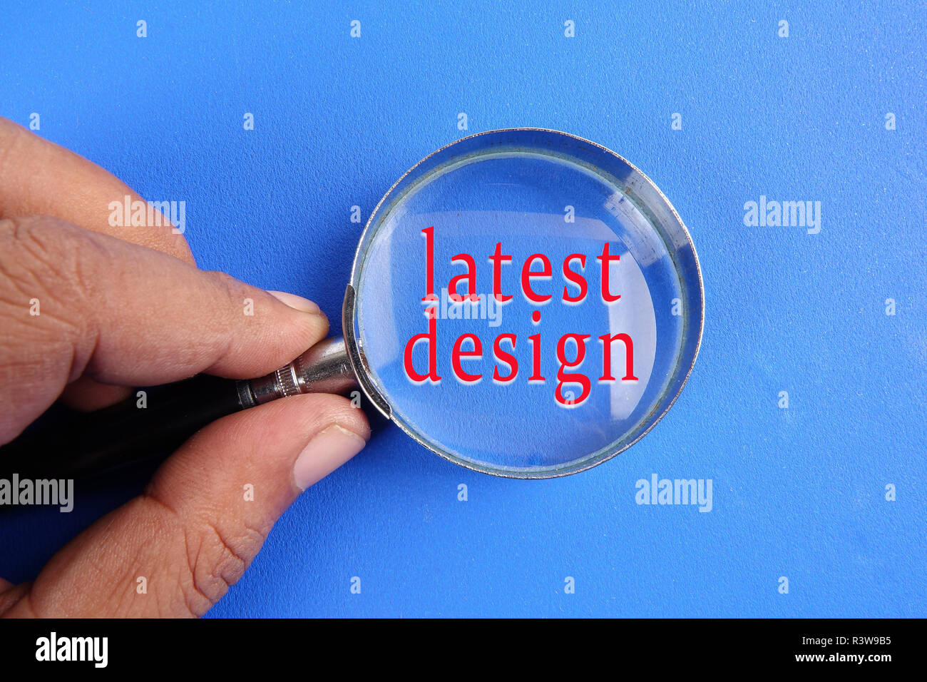 Hand holding magnify glass over a blue background with LATEST DESIGN ...