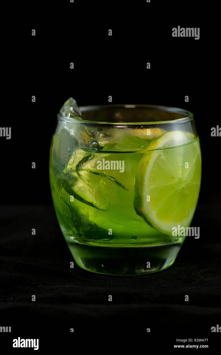 Green cocktail with gin, bitter lemon, basil and lemon with isolated ...