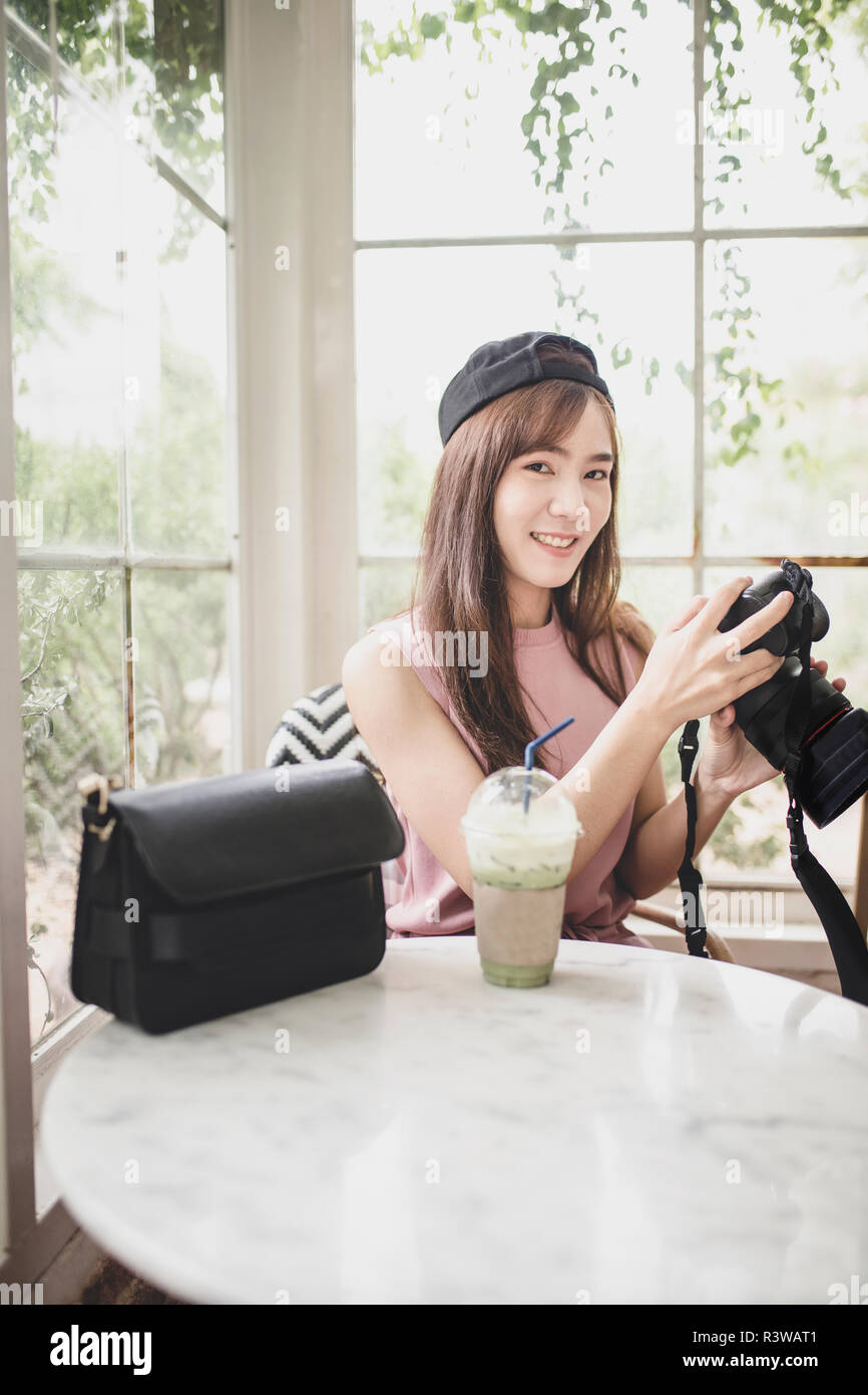portrait younger asian woman relaxing holding dslr camera in hand Stock ... portrait younger asian woman relaxing holding dslr camera in hand Stock ...
