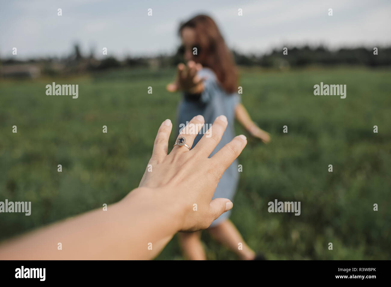 Hand reaching out for woman on a field Stock Photo - Alamy