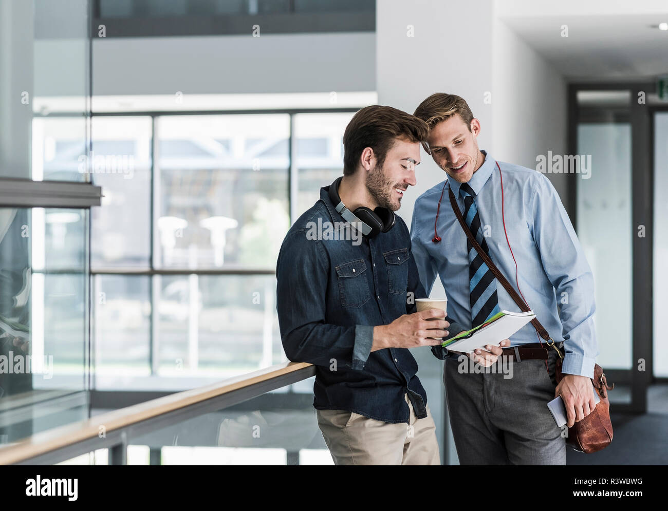 Two colleagues talking on office floor Stock Photo - Alamy