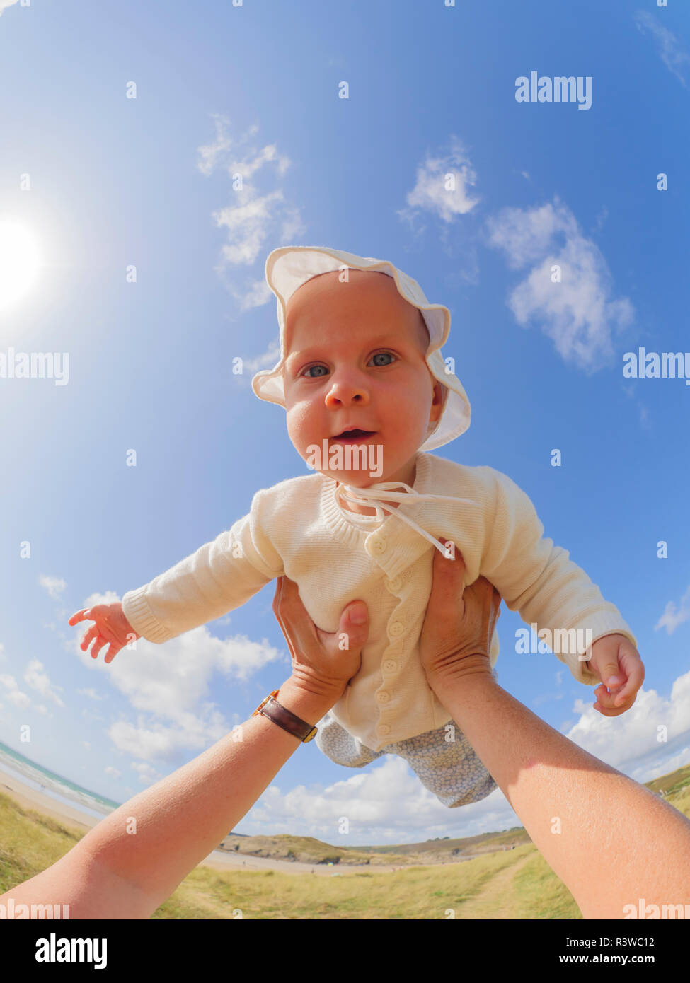 Portrait of baby girl holding aloft by her mother Stock Photo - Alamy