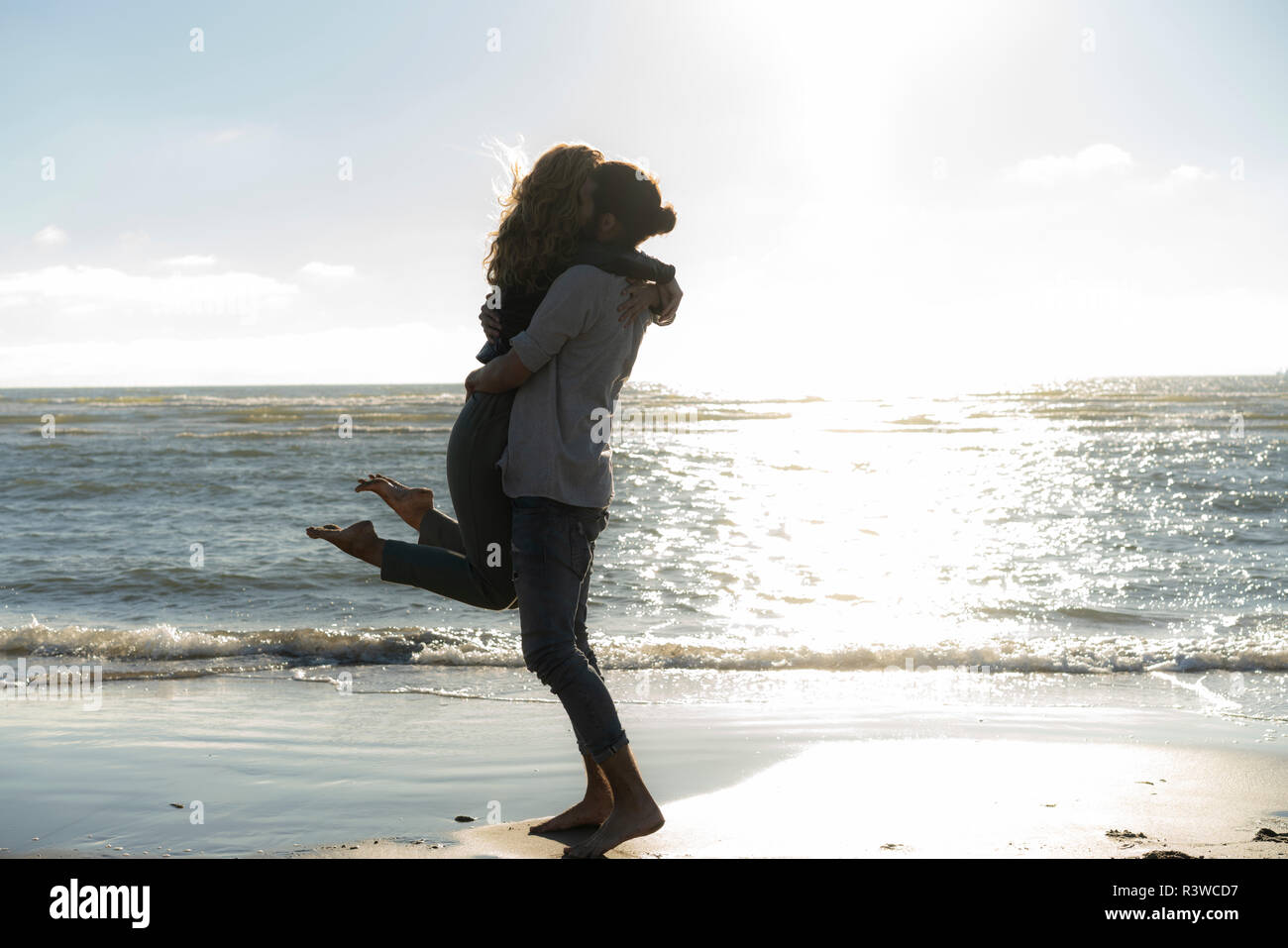 Happy couple embracing on the beach Stock Photo - Alamy