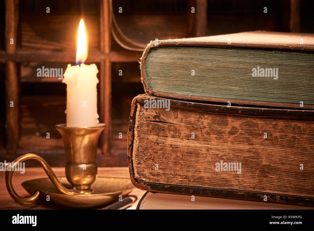 Old book on wooden table by candlelight Stock Photo - Alamy