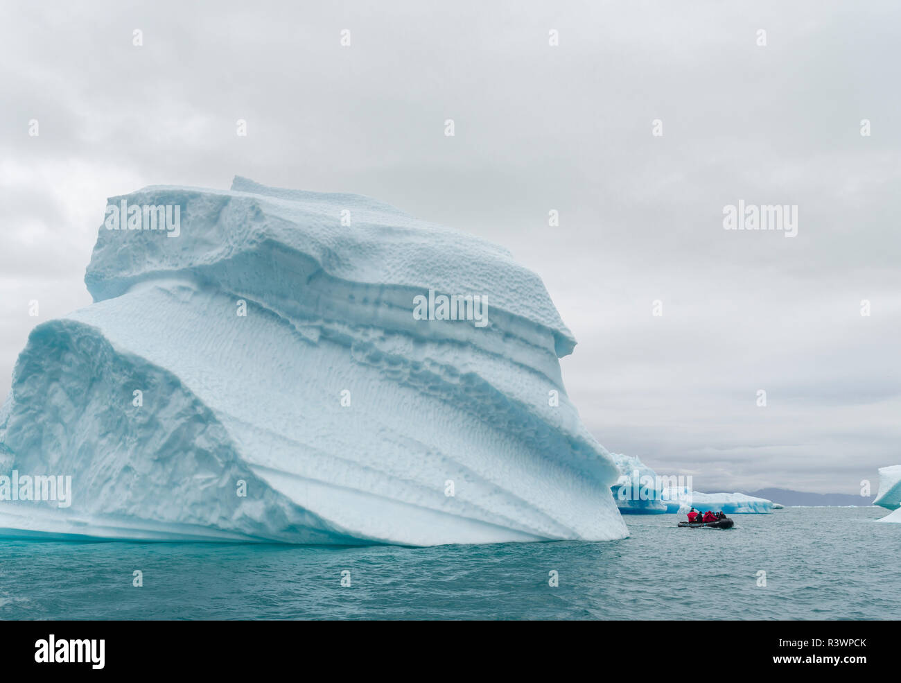 Tourists in Zodiac with icebergs drifting in the fjords of southern ...