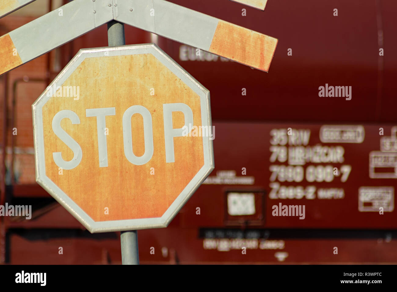 Old faded stop sign with a cross in front of a train wagon Stock Photo ...