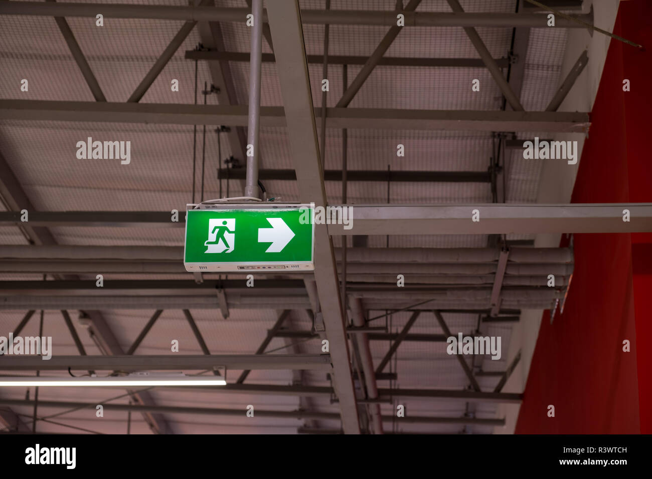 Fire exit light sign. Green emergency exit sign showing the way to ...