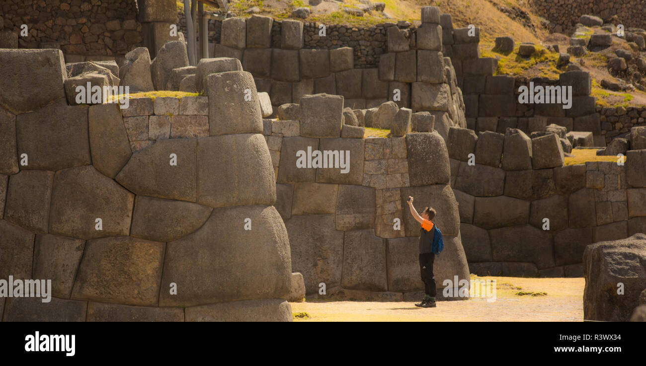 Saksaywaman, Cusco, Peru. A Tourist takes a picture of the giant stone ...