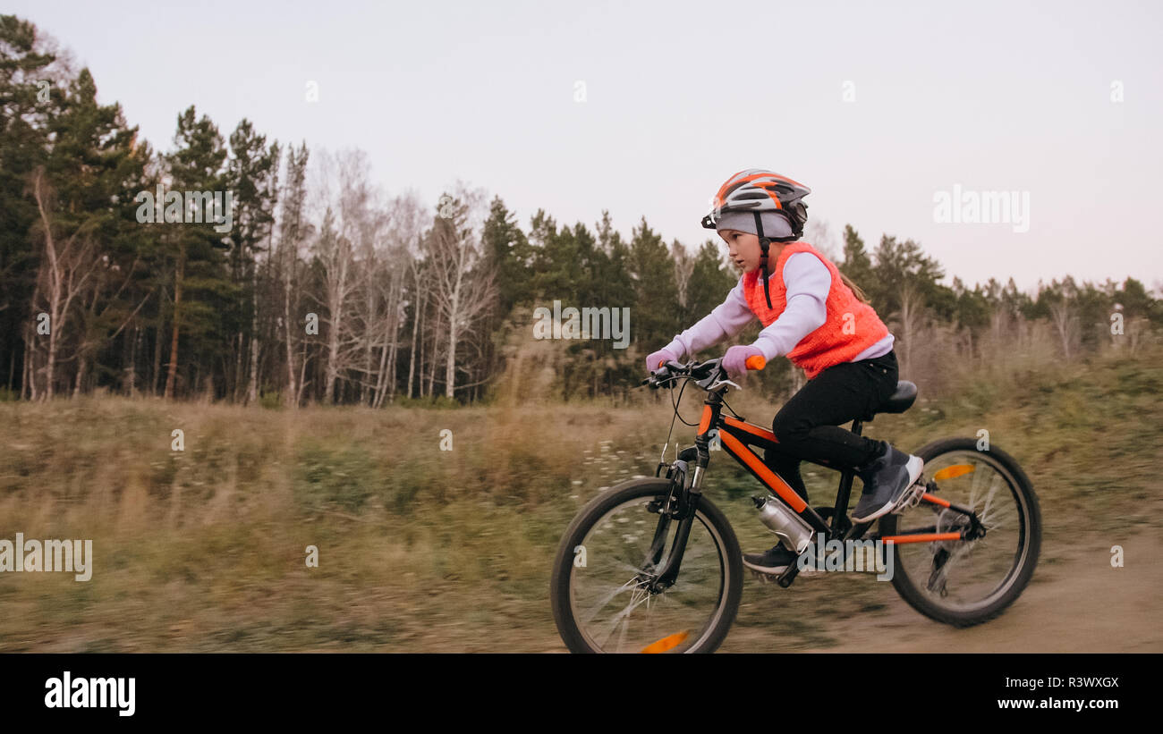 One caucasian children rides bike road track in dirt park. Girl riding ...