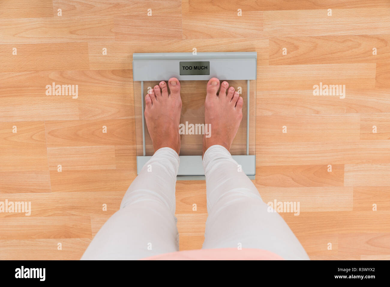 Woman Standing On Weighing Scale Stock Photo - Alamy