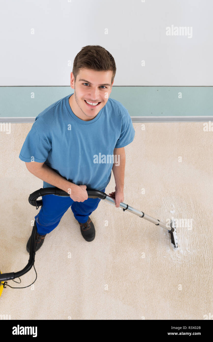 Male Janitor Vacuuming Corridor Stock Photo - Alamy