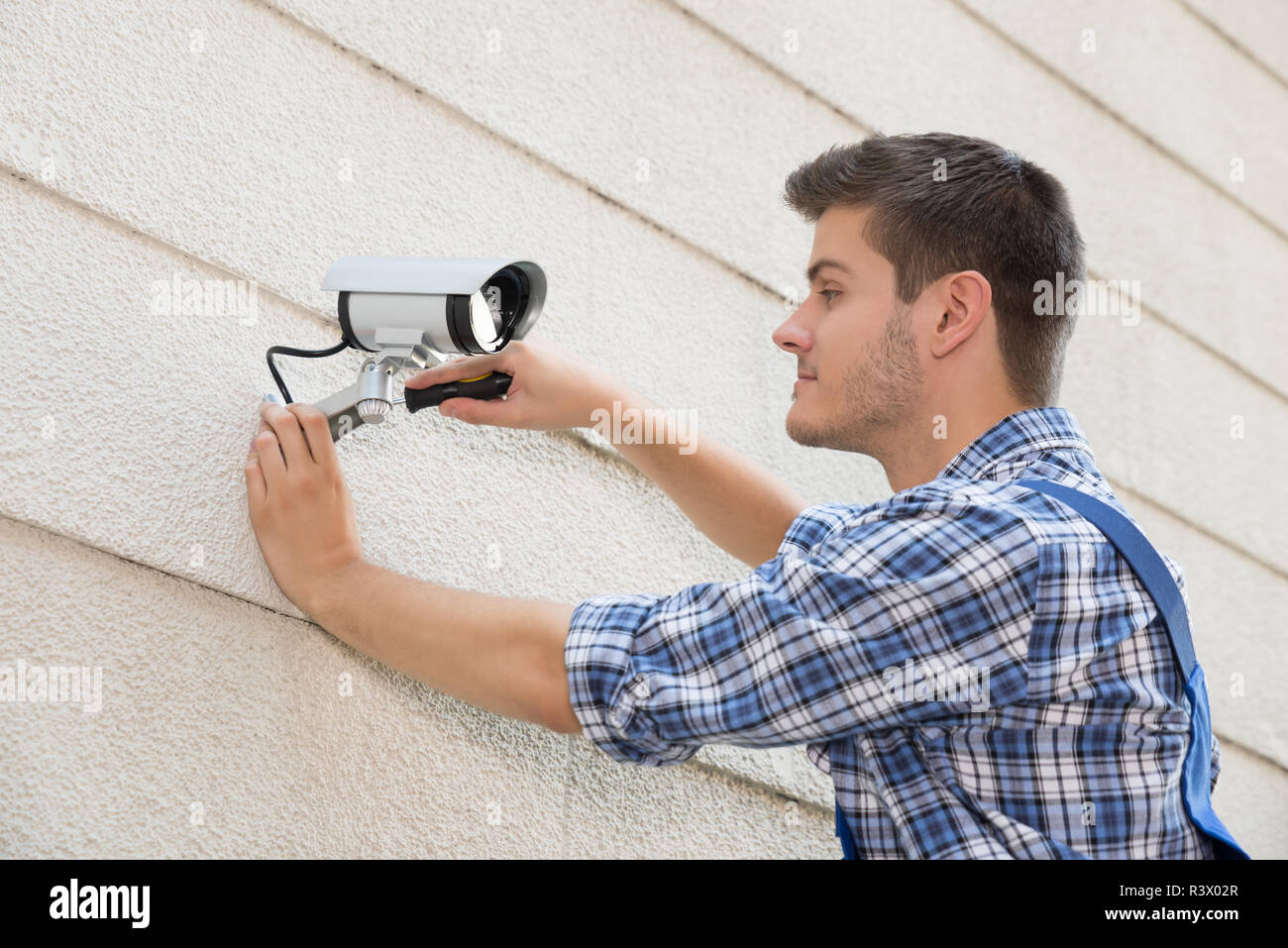 Technician Fixing Cctv Camera On Wall Stock Photo - Alamy