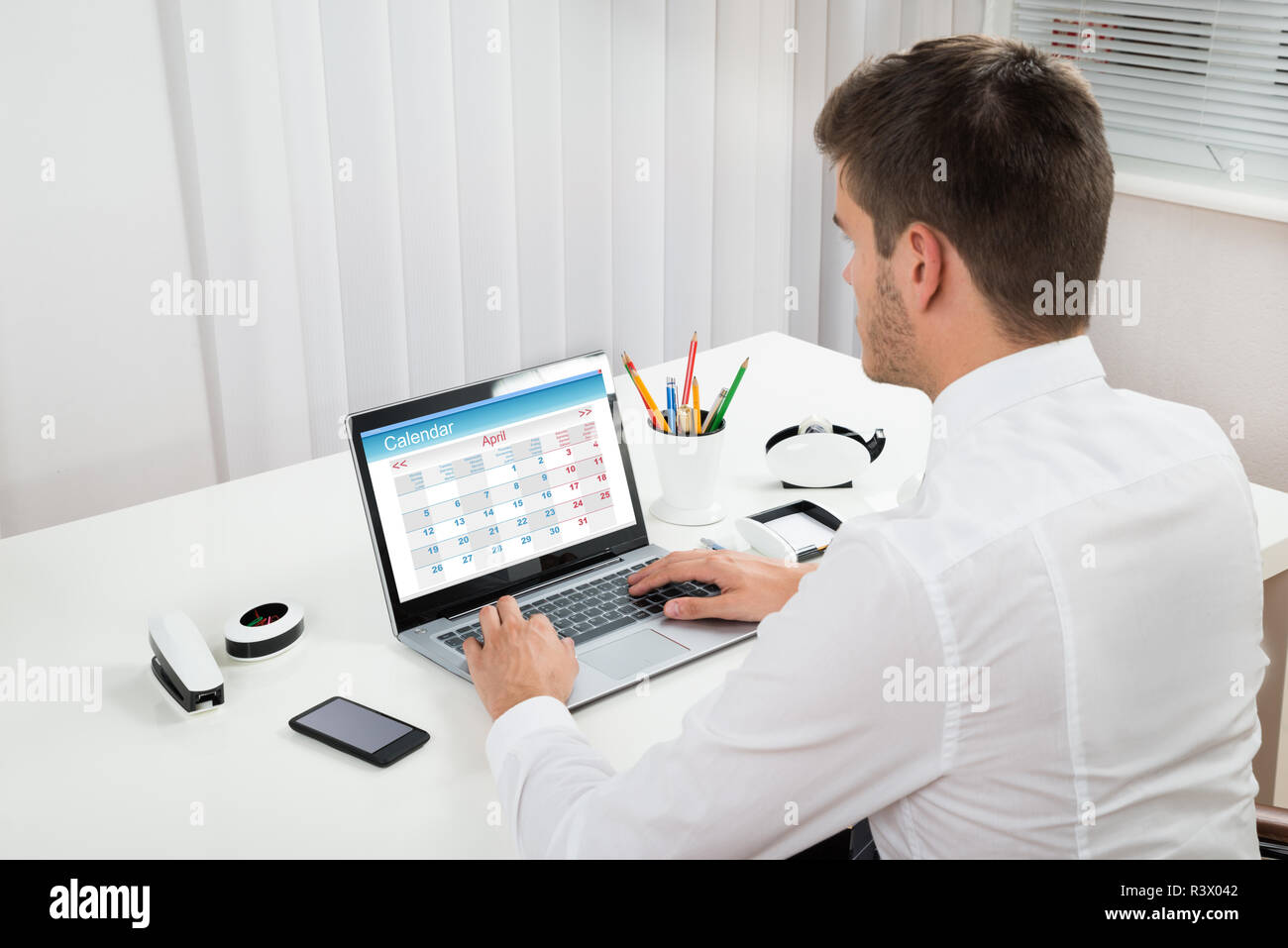 Businessman Looking At Calendar On Laptop Stock Photo - Alamy