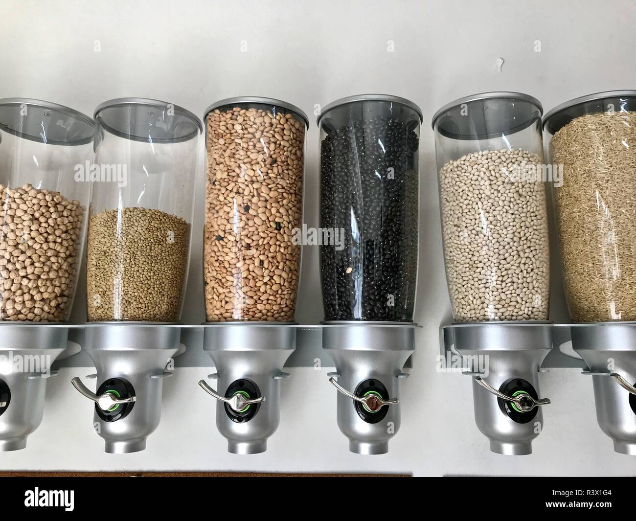 Wall mounted containers at a zero waste store full of lentils, beans ...