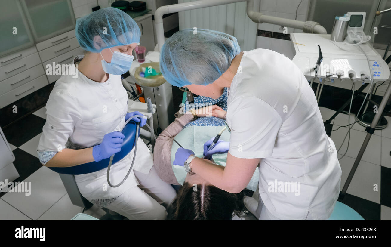 Woman at dentist clinic gets dental treatment to fill a cavity in a ...