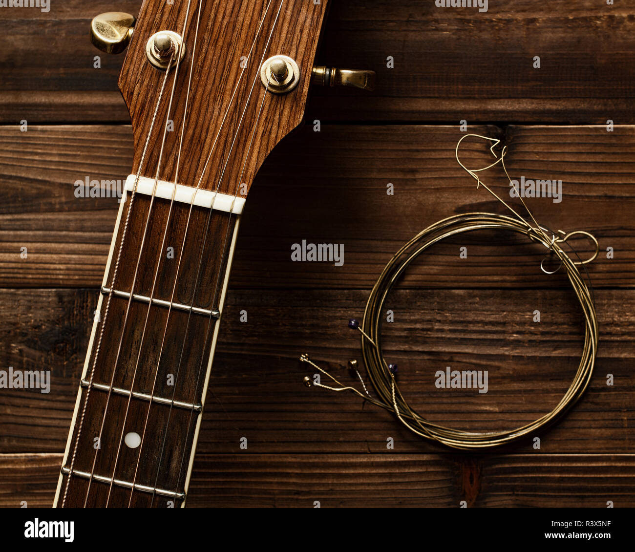 Acoustic guitar neck and old strings on wood in natural light Stock ...