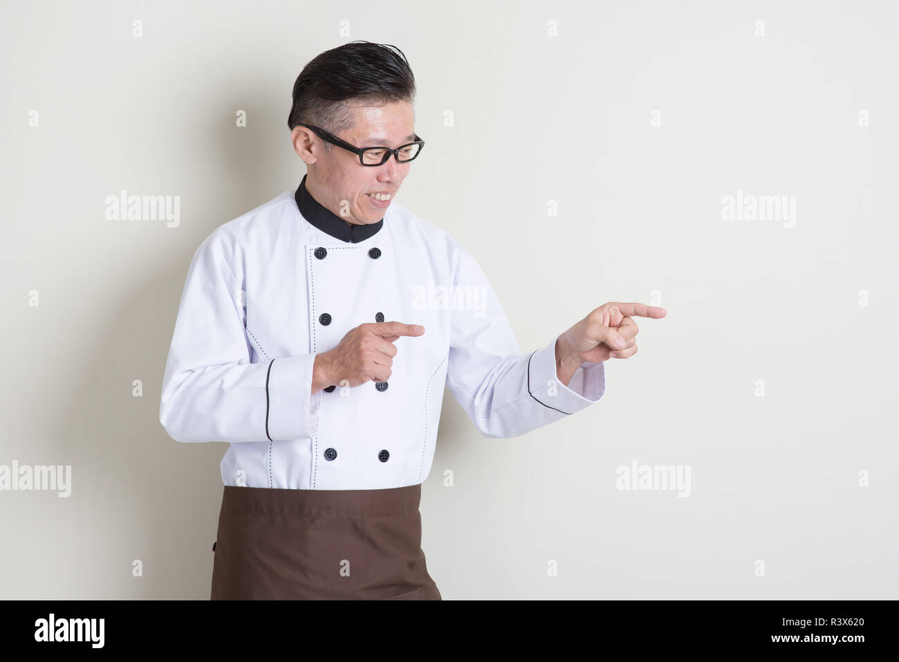 Smiling senior cook pointing finger hi-res stock photography and images ...