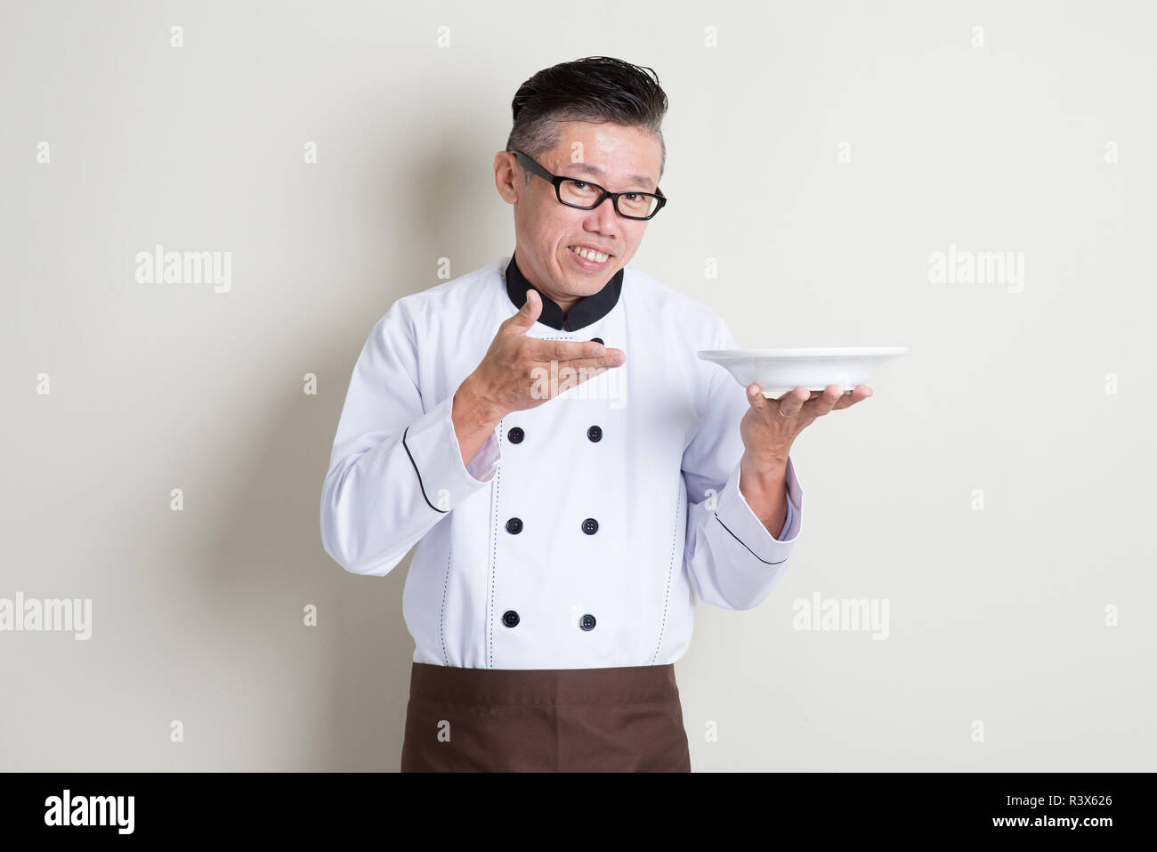 Mature Asian Chinese chef presenting dish Stock Photo - Alamy