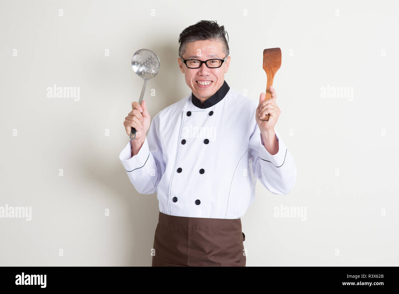 Mature Asian Chinese chef with kitchen tools Stock Photo - Alamy