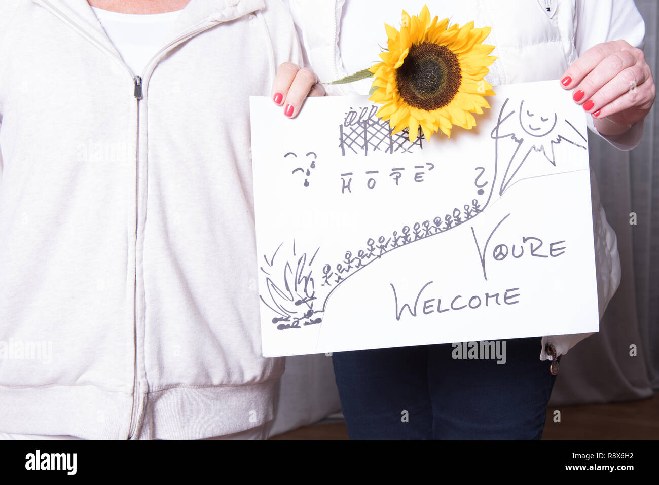 female helpers welcome refugees Stock Photo - Alamy
