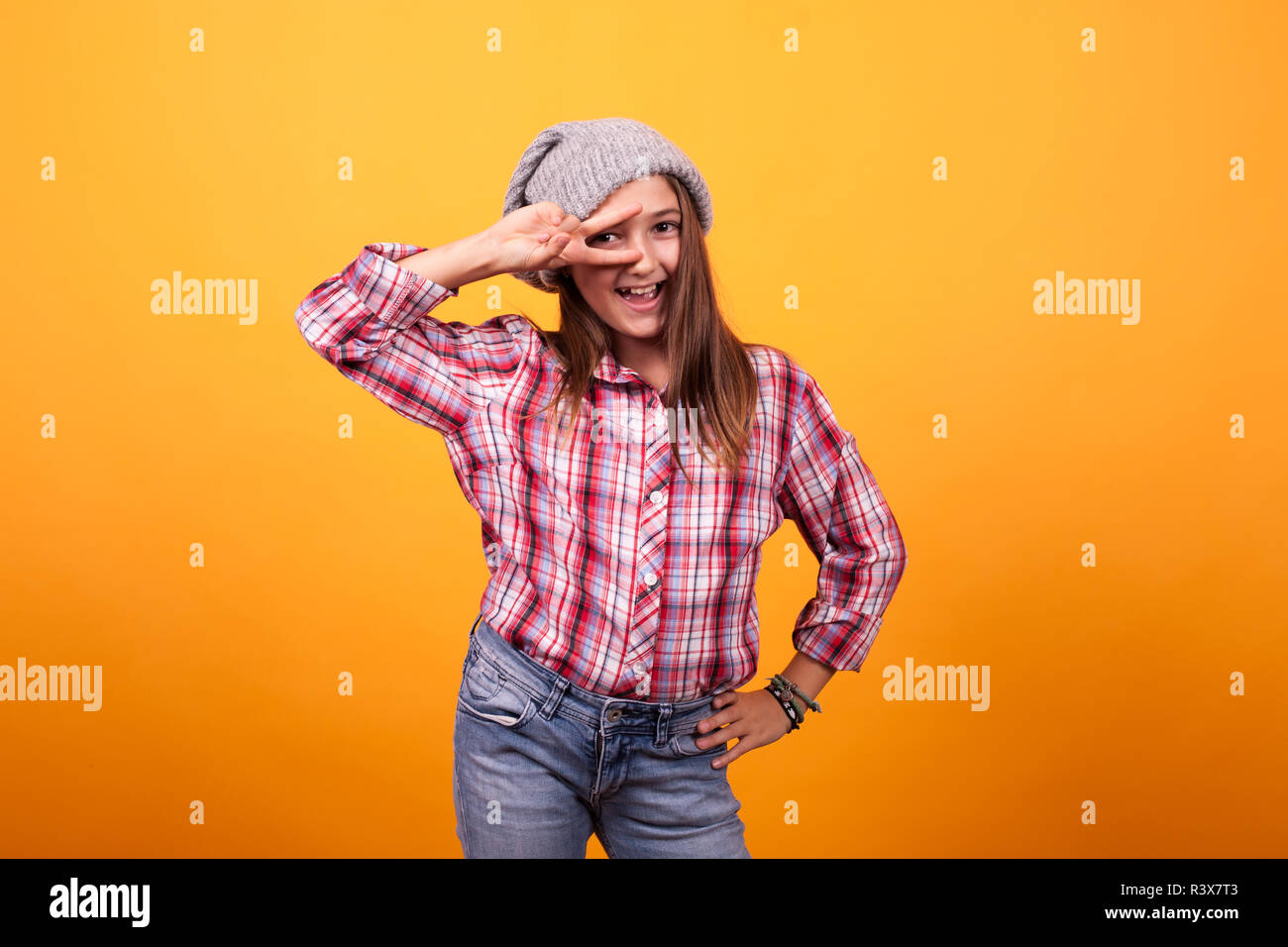 Happy kid fooling around in studio on yellow background.Funny time ...