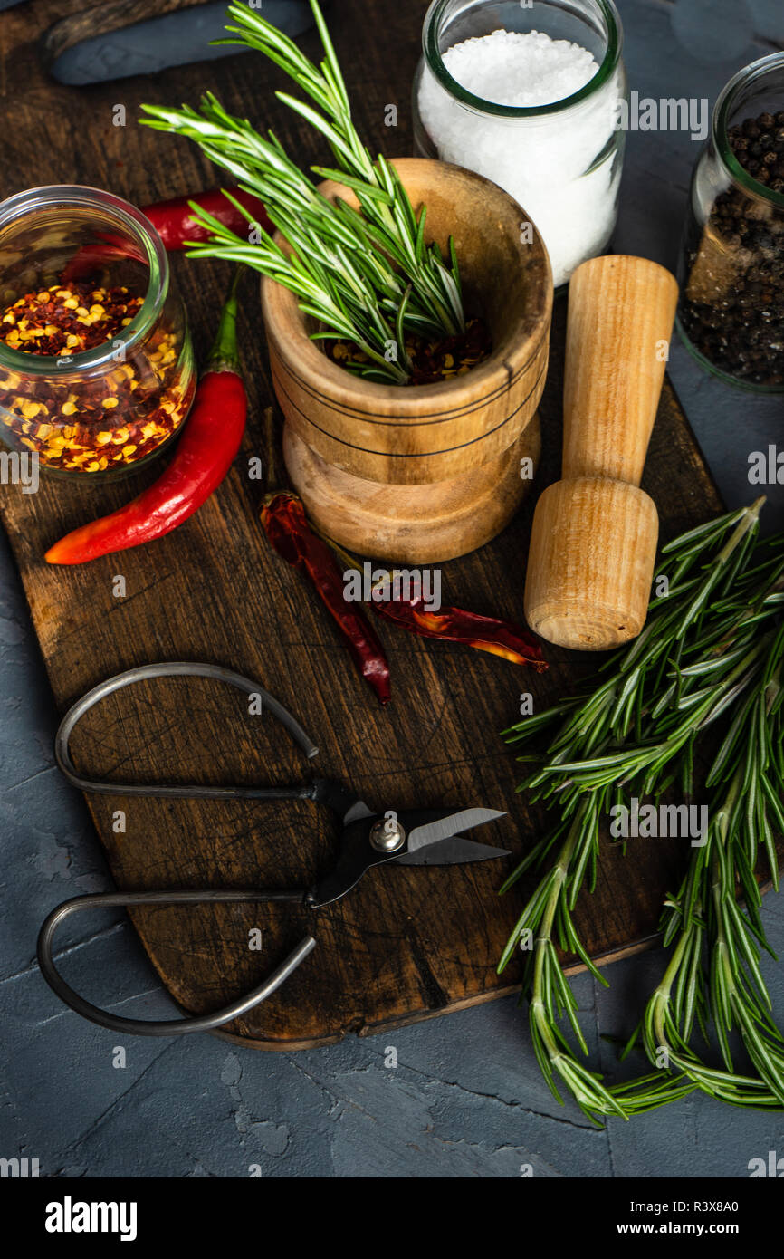Organic spices like pepper, rosemary, different types of salt on rustic ...