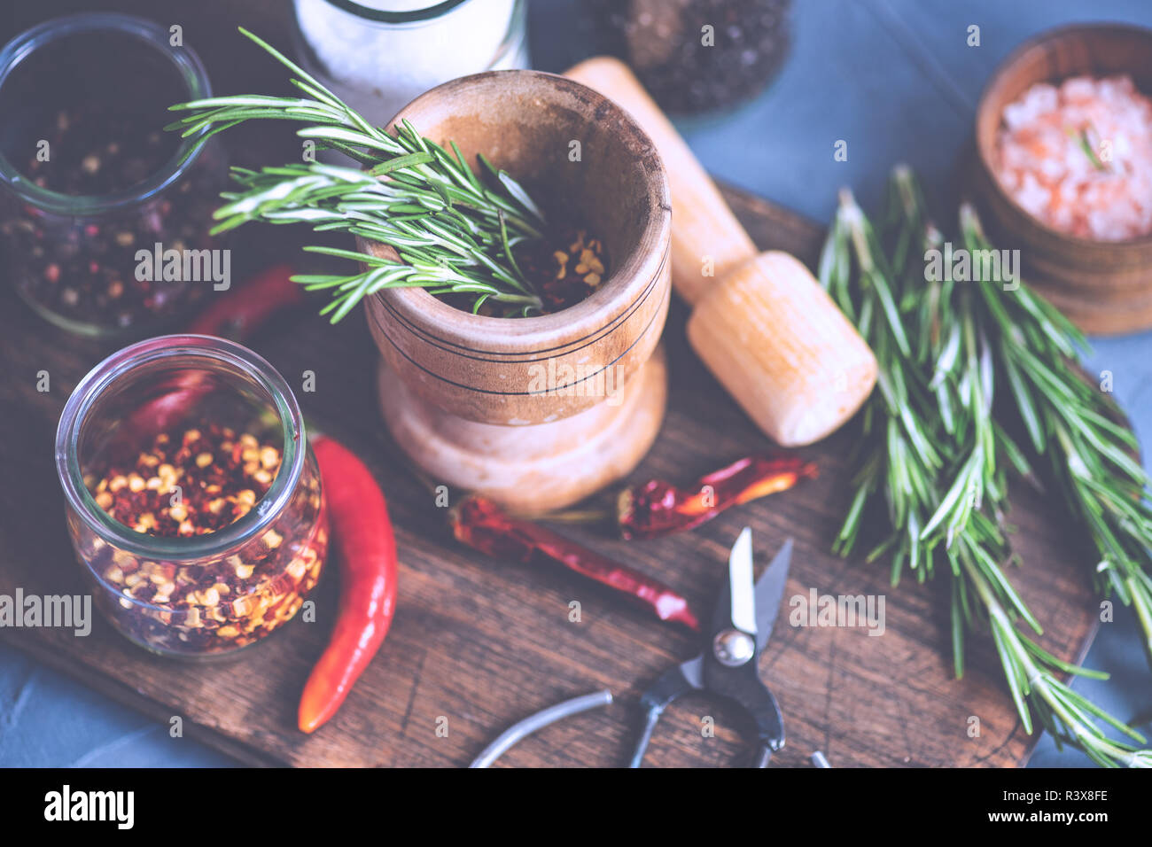 Organic spices like pepper, rosemary, different types of salt on rustic ...