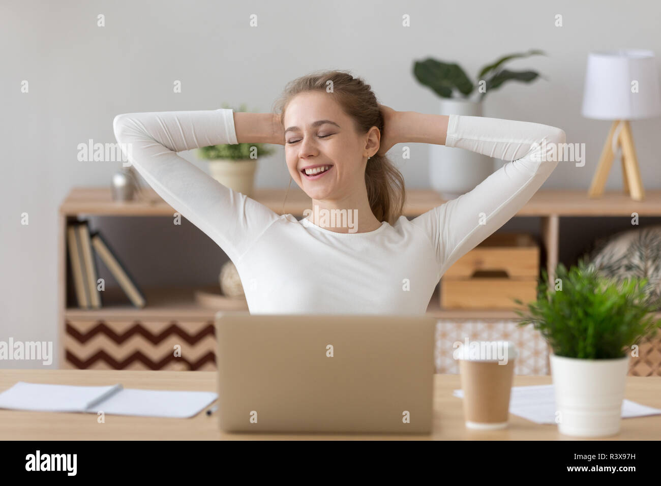 Happy girl lean back in chair working at home desk Stock Photo - Alamy