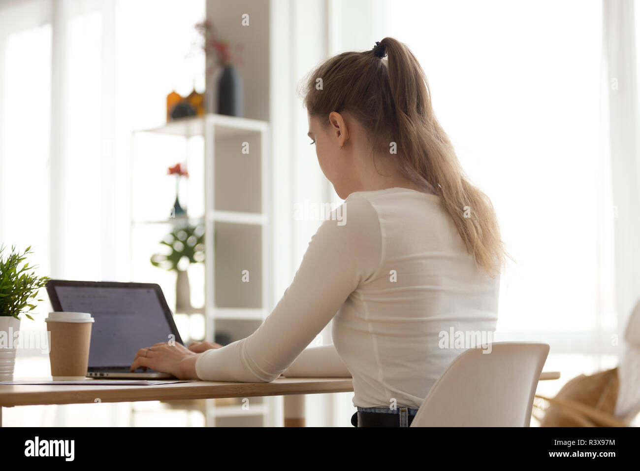 Focused girl typing at laptop working from home Stock Photo - Alamy