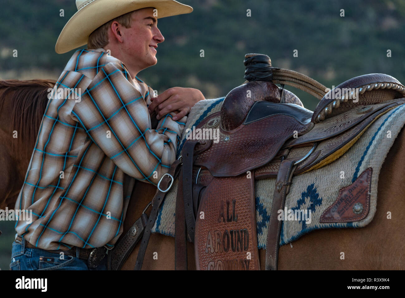 USA, California, Parkfield, V6 Ranch young smiling cowboy standing my ...