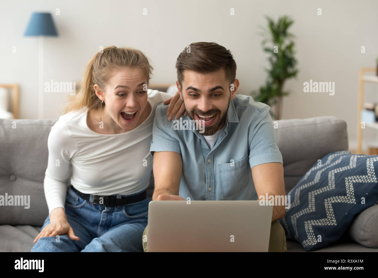 Excited couple shocked by unexpected online win Stock Photo - Alamy