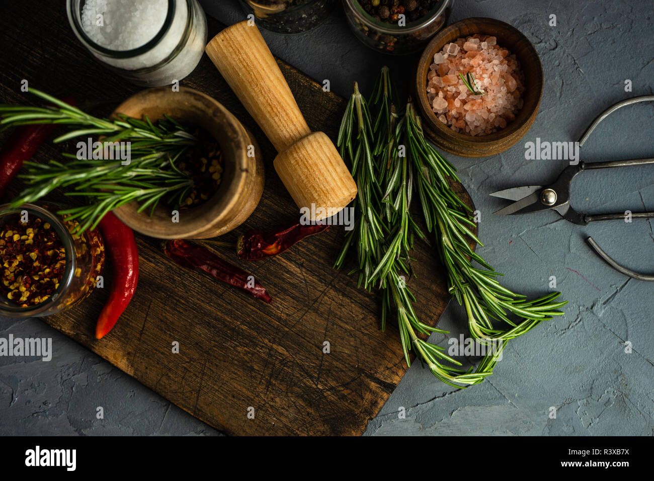 Organic spices like pepper, rosemary, different types of salt on rustic ...