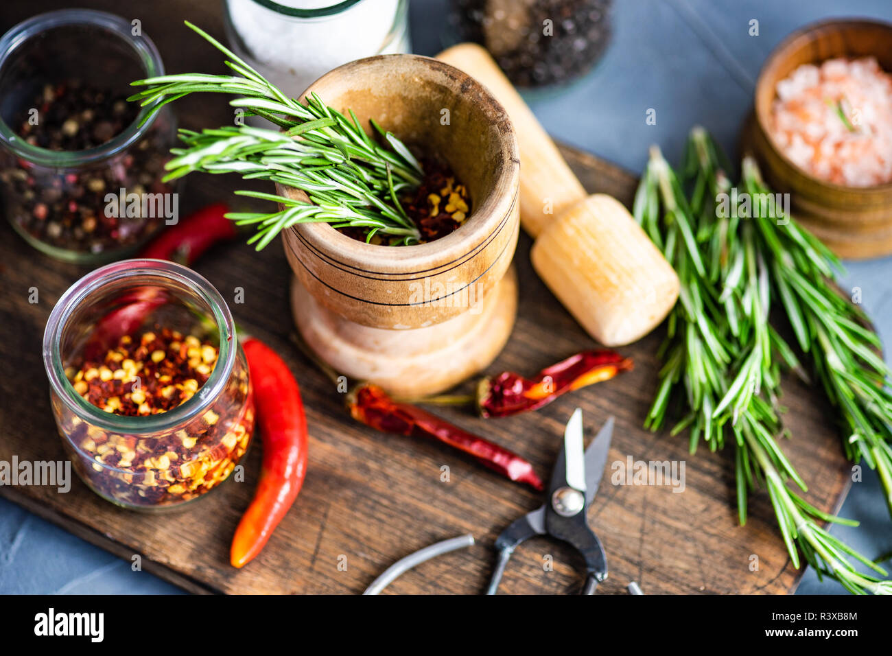 Organic spices like pepper, rosemary, different types of salt on rustic ...