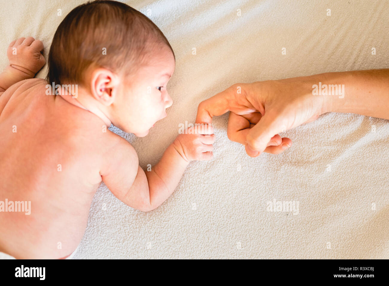 Newborn baby holding his mother's hands tenderly Stock Photo - Alamy
