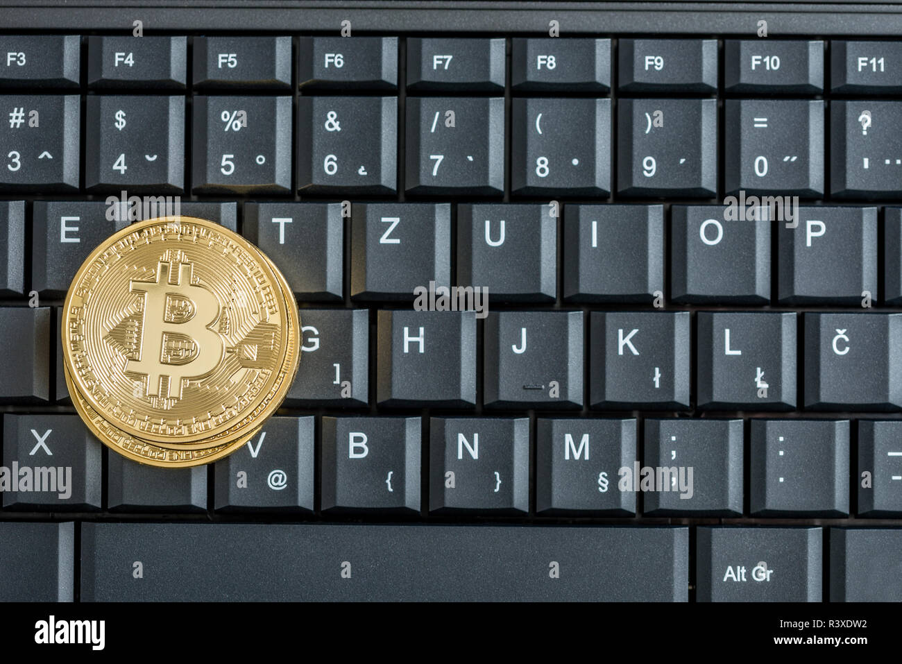 Top view of golden bitcoins on a black keyboard conceptual of digital ...