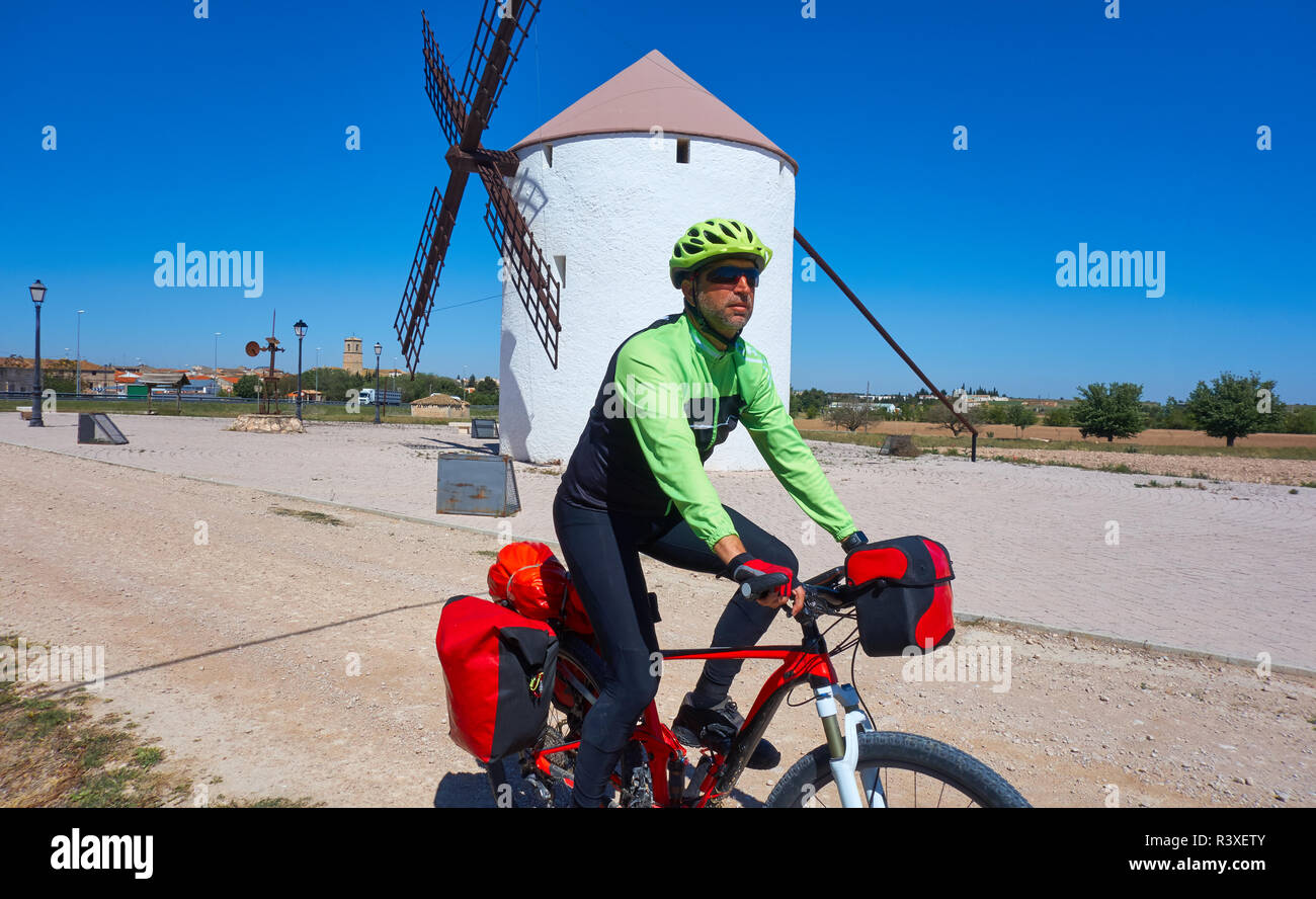 Biker pilgrim by Camino de Santiago in bicycle at windmill of Castile ...