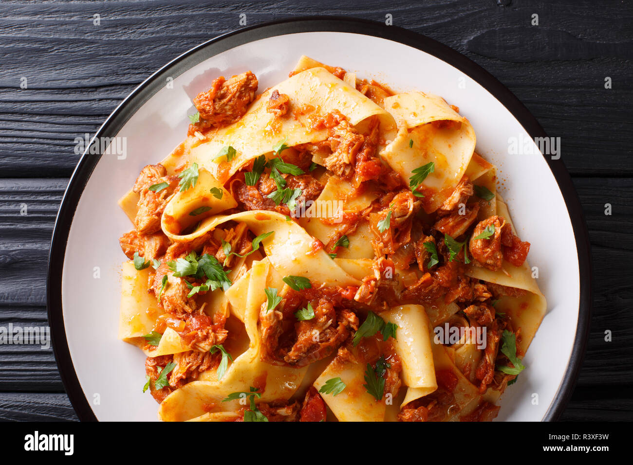 Pasta with Braised Pork Shoulder Ragu close-up on a plate on the black ...