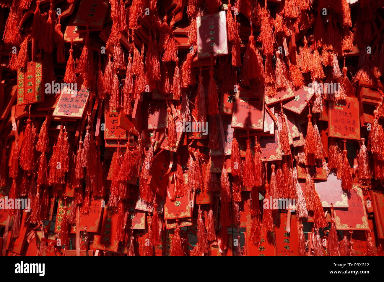 Hundreds of red prayer tablets with tassels hanging at a temple in ...