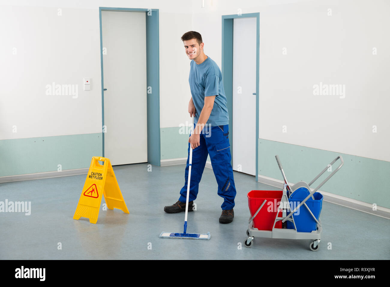 Male Worker With Cleaning Equipments Mopping Floor Stock Photo - Alamy