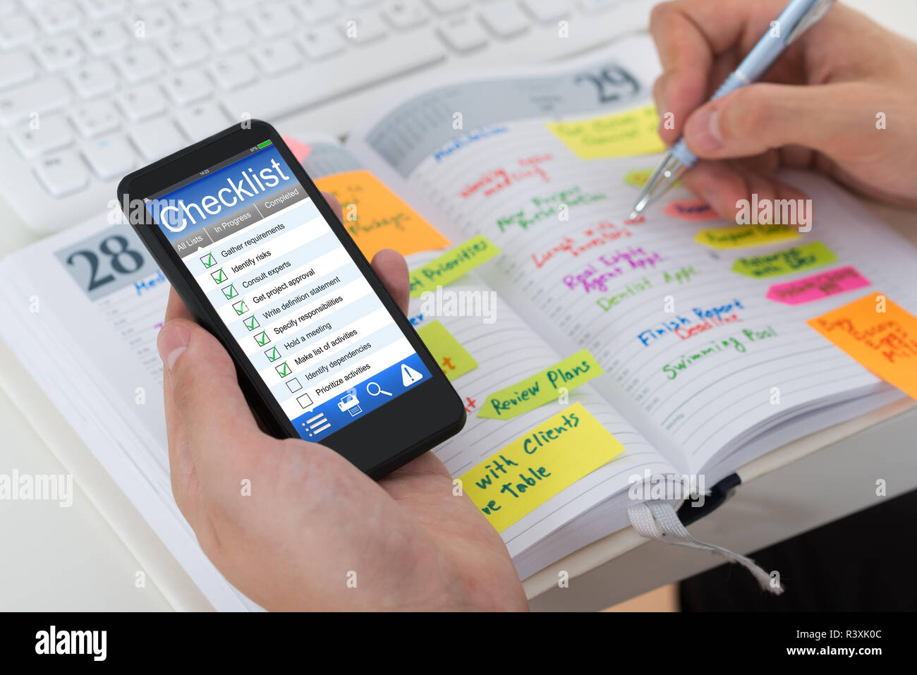 Person Checking List From Mobile Phone And Diary Stock Photo - Alamy
