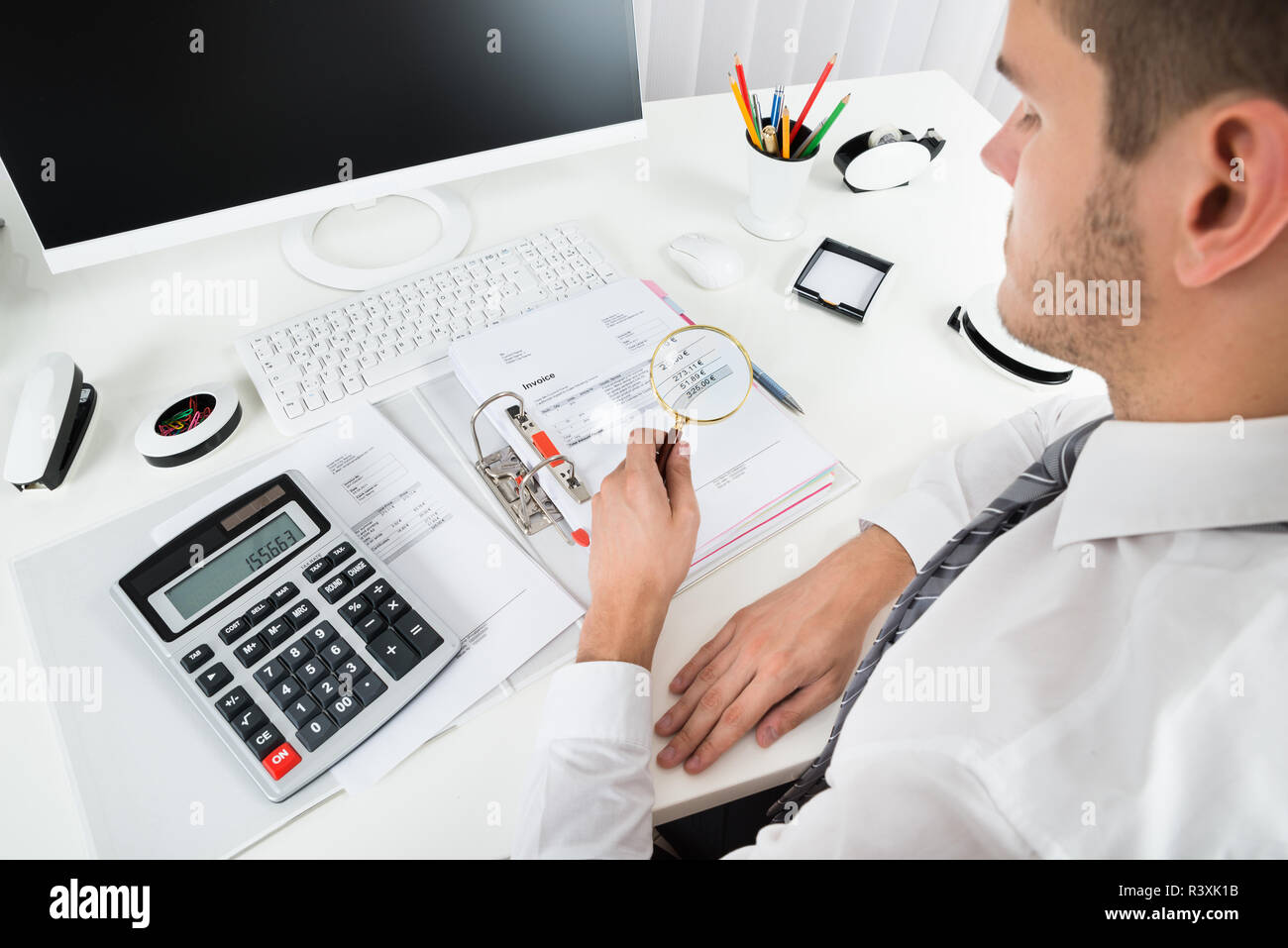 Businessman Checking Invoice With Magnifying Glass Stock Photo - Alamy