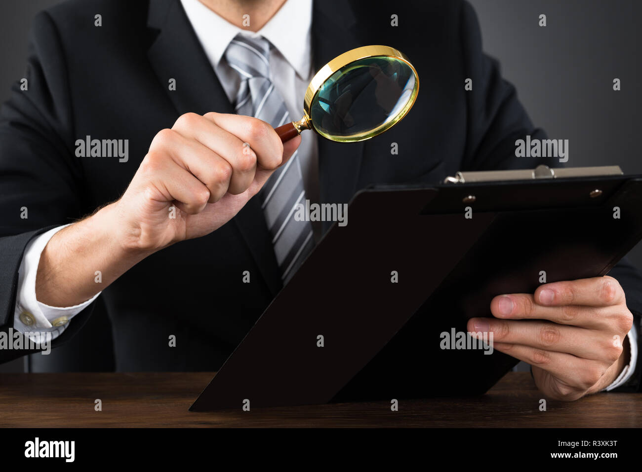 Businessperson Inspecting Document With Magnifying Glass Stock Photo ...